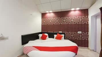 Quarto de hotel com cama, parede estampada e porta.