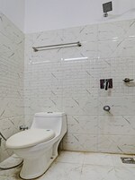 Casa de banho com sanita, chuveiro e secador de mãos.