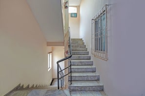Uma escadaria com grades de metal que leva a um patamar com janela.