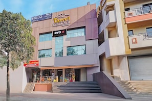Um hotel com uma placa indicando 'Tanvi Grand' e 'Oyo' hotel.