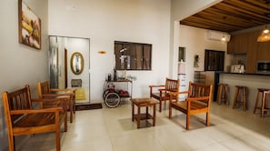 Quarto com móveis de madeira, uma bicicleta e uma cozinha.