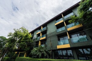 Edifício de vários andares com design arquitetônico moderno, com sacadas e grandes janelas.