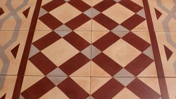 Piso com padrão geométrico de azulejos claros e escuros alternados.