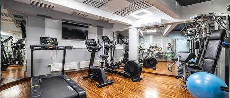 Academia moderna com esteiras, elípticos e equipamentos de musculação.