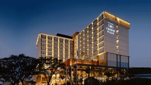 Um hotel de vários andares com uma placa chamativa que diz 'Crown Plaza'.