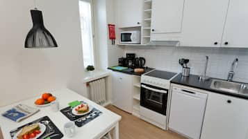 Um frigorífico/congelador grande, um micro-ondas, uma placa de cozinha