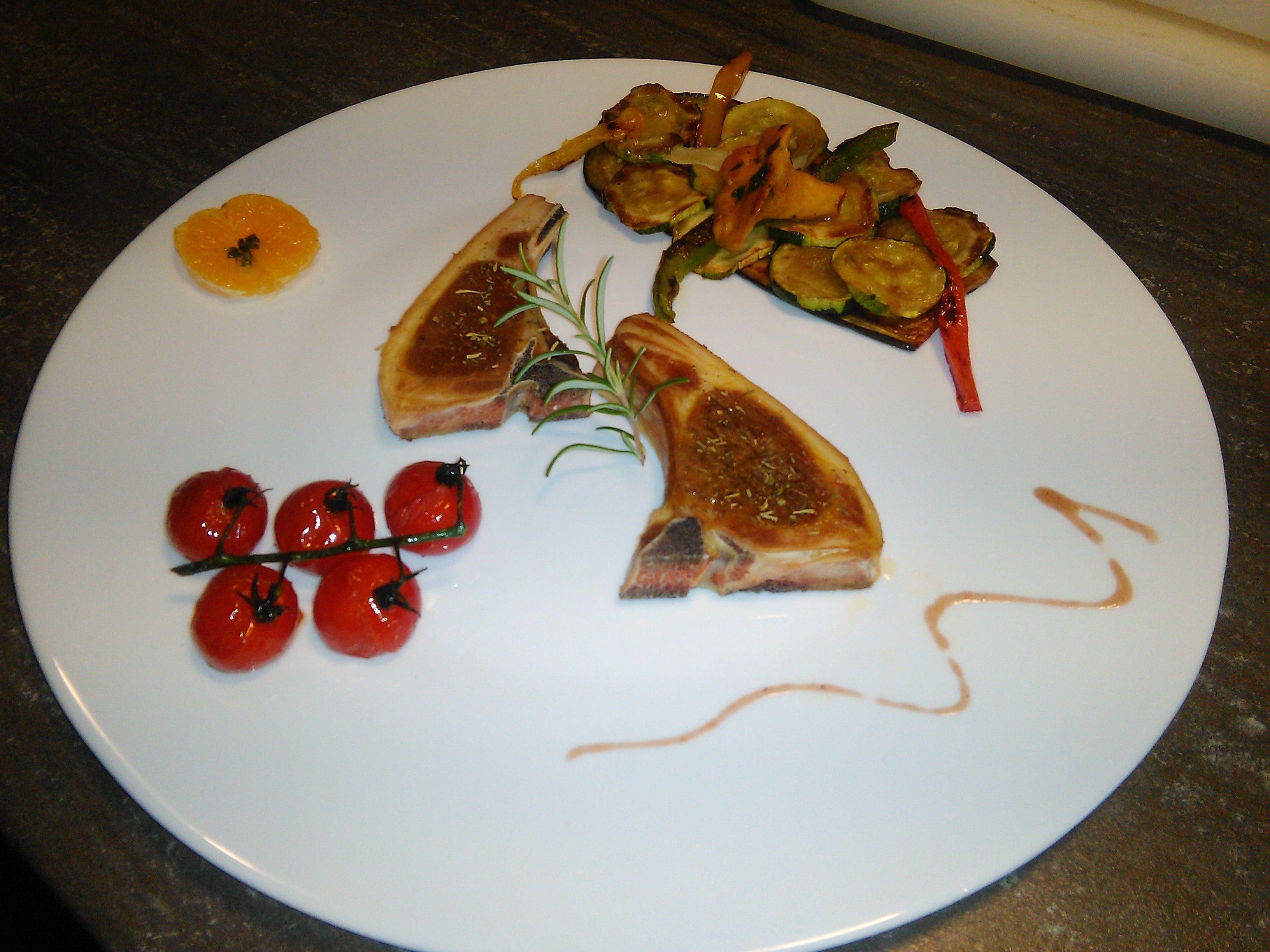 Um prato com carne grelhada, legumes e tomates cereja.