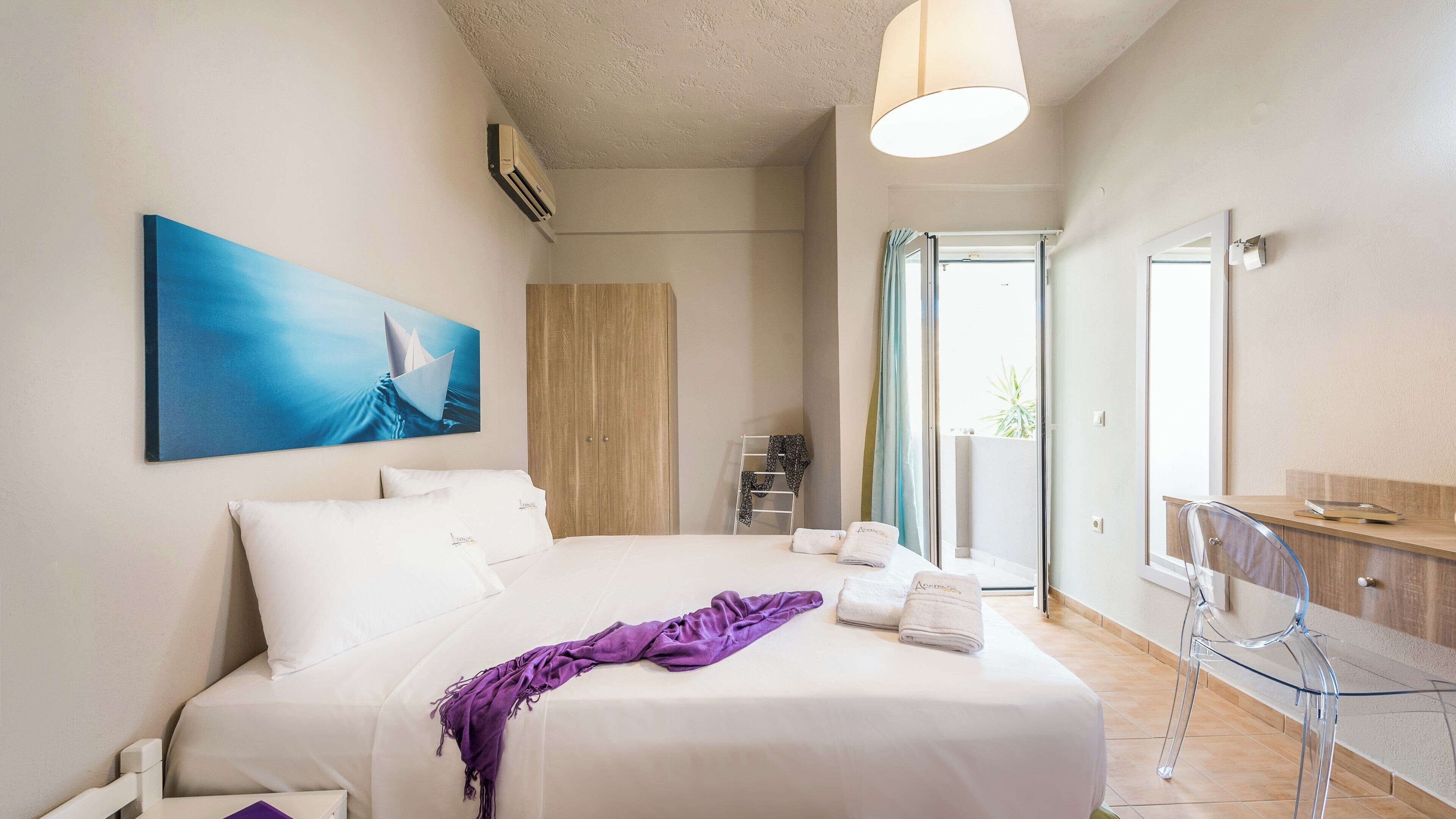 Quarto de hotel com cama, banheiro, varanda e vista para o exterior.