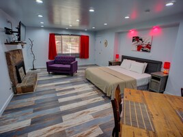 Quarto de hotel com cama, sofá, mesa e uma cadeira.