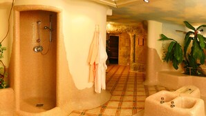 Um banheiro estilo spa, com chuveiro, banheira e poltrona de massagem.