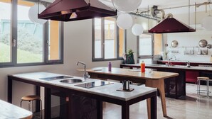 Cozinha moderna com ilha central, eletrodomésticos de aço inoxidável e iluminação pendente.