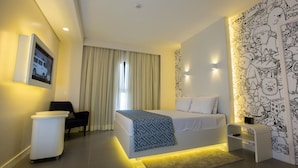 Quarto moderno com cama, mesa de cabeceira e parede com mural em preto e branco.