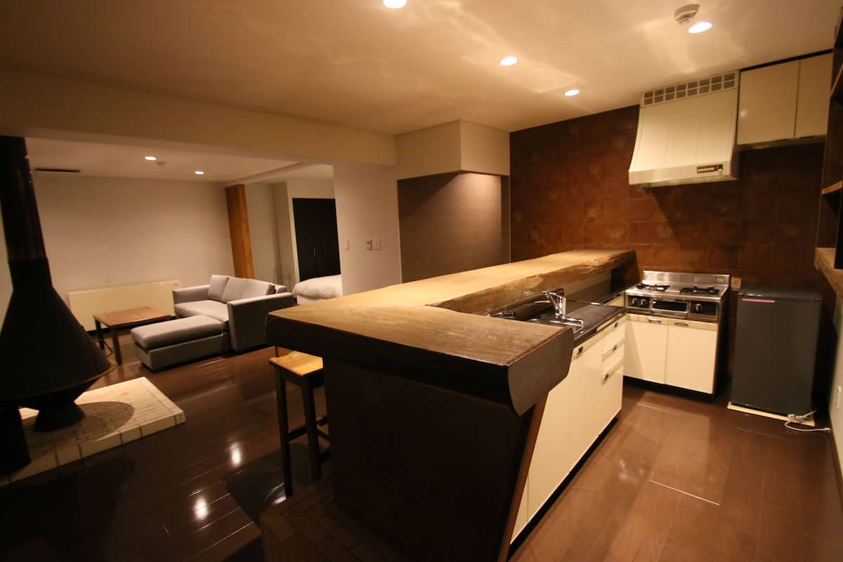 Uma cozinha moderna com ilha central, forno embutido e armários brancos.