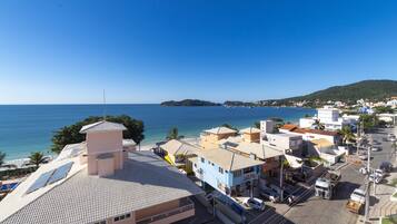 Uma cidade costeira com edifícios, céu azul claro e o mar ao fundo.