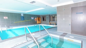 Piscina interior com água cristalina, níveis de profundidade indicados e aviso de proibição de mergulhos.