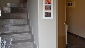 Uma escadaria leva a um patamar com um quadro emoldurado na parede.