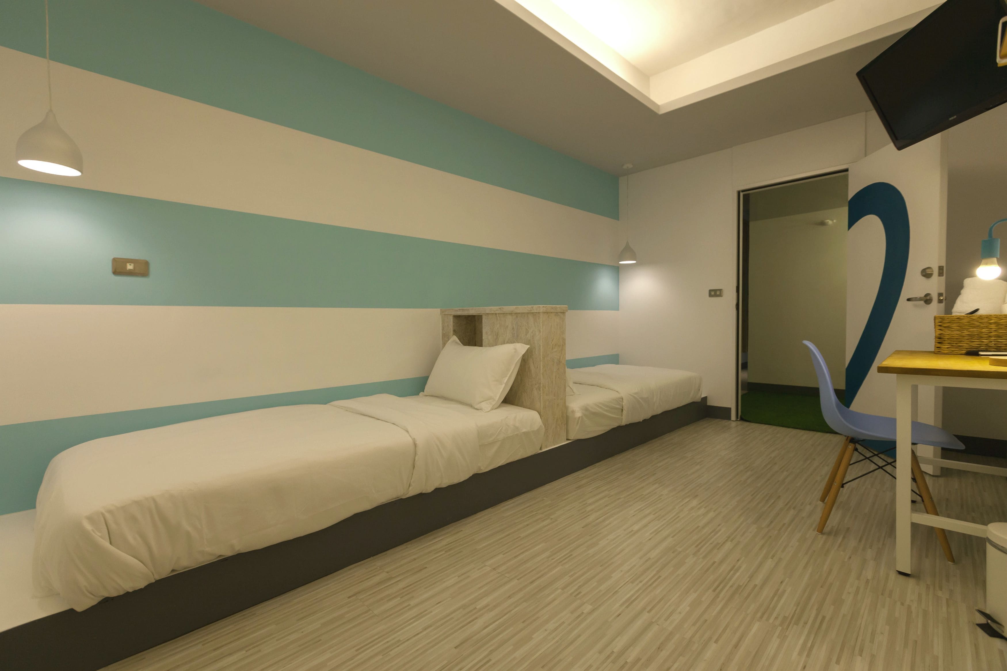 Um quarto com uma cama, uma escrivaninha e uma cadeira.