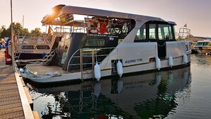 Um barco atracado em um cais, com deck superior coberto e cabine.