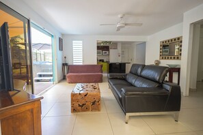 Uma sala de estar com sofá, mesa de centro e televisão.