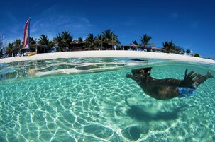 Na praia, praia de areia branca, espreguiçadeiras, guarda-sóis de praia 