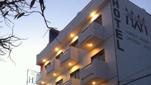 Um hotel com fachada moderna, várias varandas e uma placa indicando ser o Hotel Miramar.