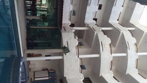 Um átrio de vários níveis com paredes brancas e texturizadas e uma estrutura de coluna central.
