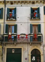 Um edifício com varandas decoradas com festões e vegetação.