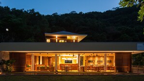 Um hotel moderno com um saguão espaçoso, área de refeições e piscina.