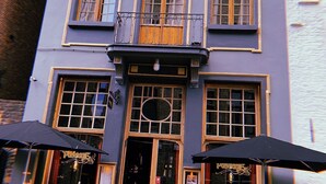 Um edifício com várias janelas, varanda e área externa com guarda-sóis.
