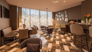 Quarto de hotel moderno com área de refeições, assentos e um bar.