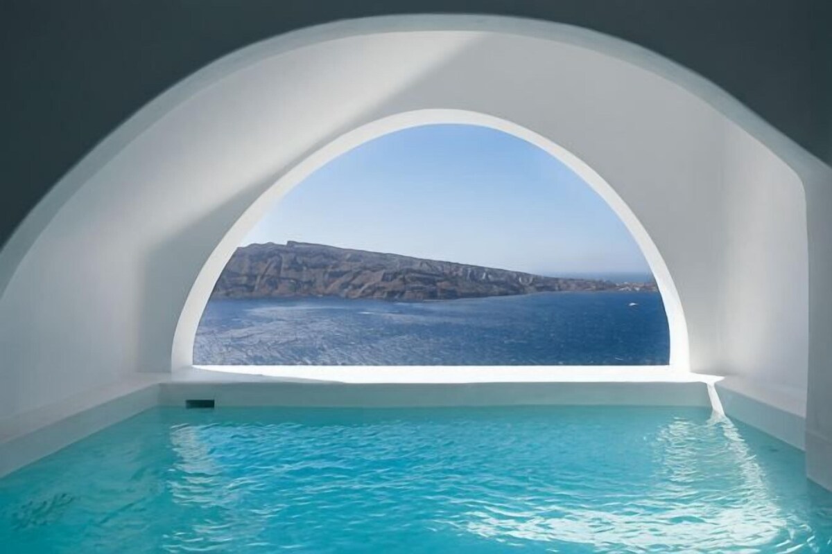 Piscina com vista desobstruída para um litoral rochoso e o mar.