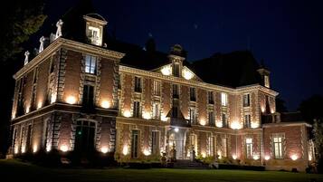Um edifício histórico amplo e iluminado, com várias janelas e uma entrada destacada.