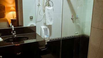 Uma casa de banho moderna com lavatório preto, sanita branca e cabine de duche em vidro.