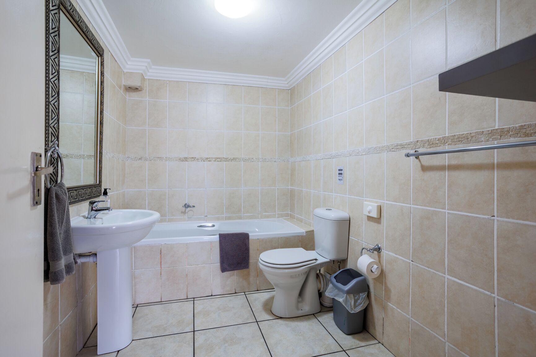 Uma casa de banho com lavatório, sanita, banheira e um porta-toalhas.