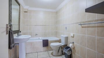 Uma casa de banho com lavatório, sanita, banheira e um porta-toalhas.