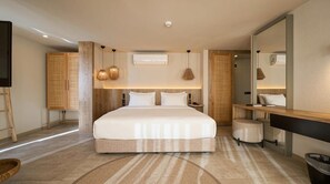 Quarto de hotel moderno com uma cama grande, um guarda-roupa de madeira, uma mesa de cabeceira, um espelho e uma televisão.