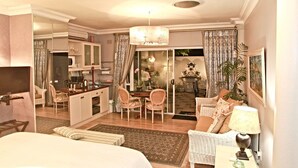 Quarto de hotel com cama, área de jantar, cozinha e varanda com vista.