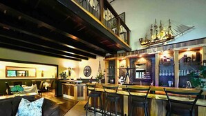Um interior moderno com área de bar, assentos e escadaria.