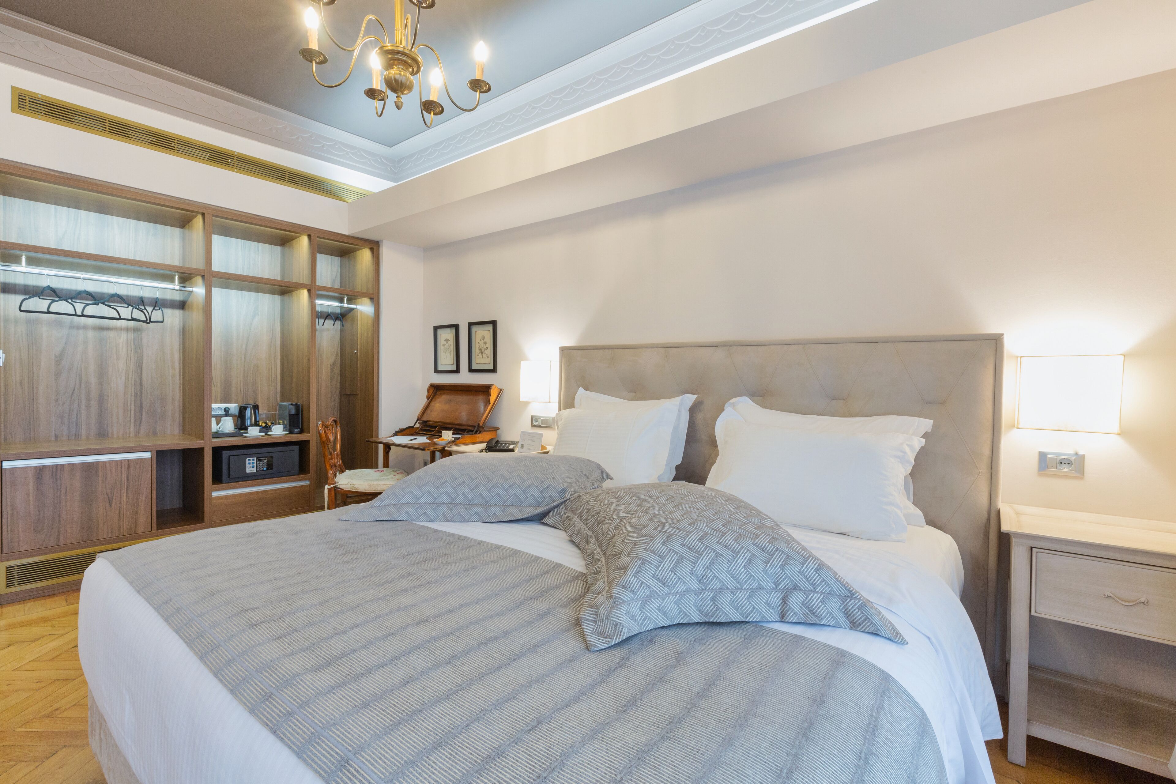 Quarto moderno com cama grande, guarda-roupa com espelhos, mesa de cabeceira e escrivaninha.