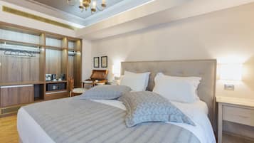 Quarto moderno com cama grande, guarda-roupa com espelhos, mesa de cabeceira e escrivaninha.
