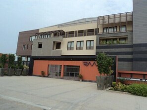 Um edifício moderno com telhado plano, várias janelas e uma placa com as letras 