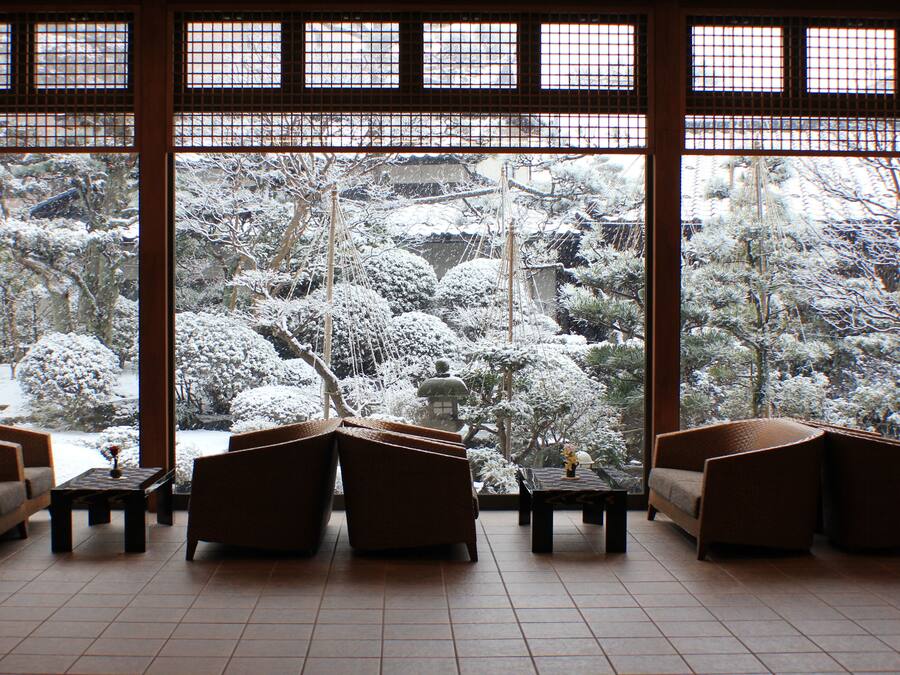 Um quarto em estilo japonês tradicional, com tatames, mesinhas baixas e assentos almofadados.