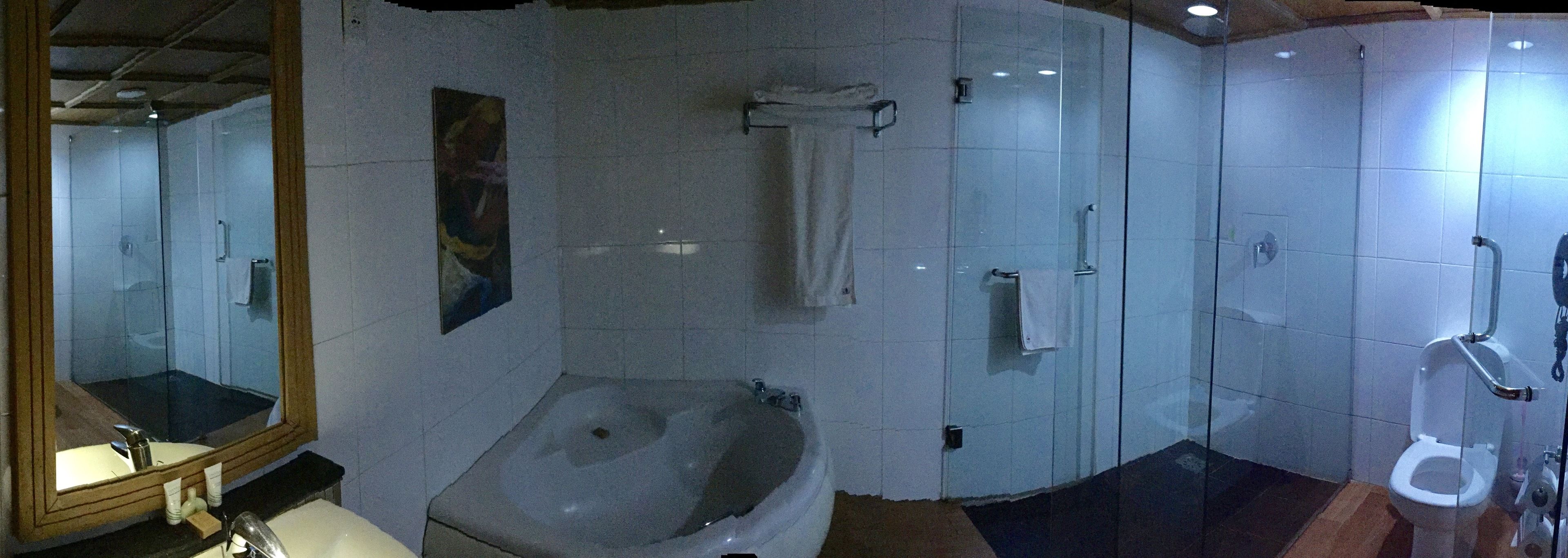 Casa de banho com bidé, sanita, lavatório e espelho.
