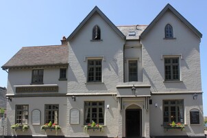 Um edifício de dois andares com uma placa que diz 'Prince of Wales'.
