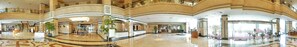 Um hall amplo com teto alto, piso de mármore e vários níveis com varandas.