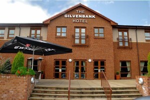 O Hotel Gilvenbank com fachada de tijolos, grandes janelas e uma escadaria que leva à entrada.