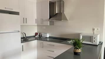 Apartamento Design, 2 quartos | Cozinha privada | Um frigorífico/congelador grande, um micro-ondas, uma placa de cozinha
