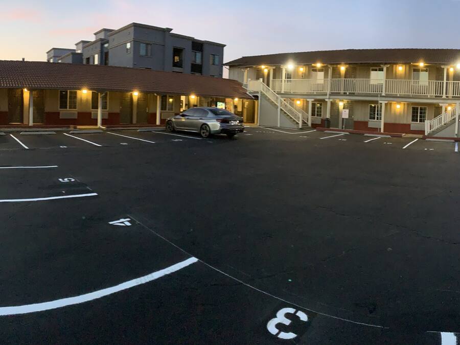 Um hotel com estacionamento, vários andares e uma escadaria que dá acesso aos níveis superiores.