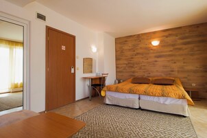 Quarto com cama, escrivaninha, cadeira e parede de madeira.
