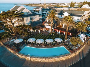 Um resort com piscina, área de estar ao ar livre e palmeiras.